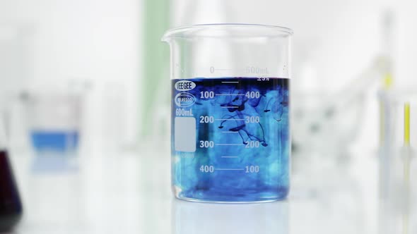 Panning view of beaker mixing blue liquid, Stock Footage | VideoHive