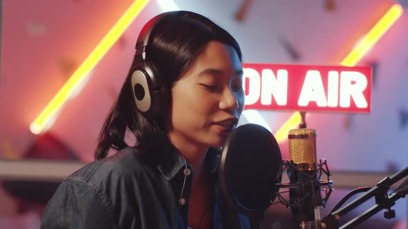 Asian Female Radio Host Speaking into Mic in Home Studio, Stock Footage
