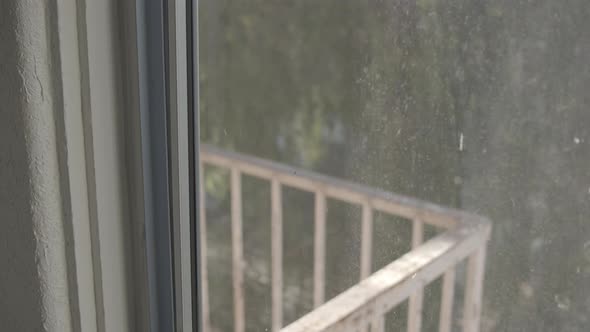 Macro shot of dirt on window that overlooks the railing of a balcony ...