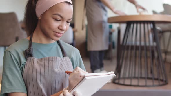 Portrait of Waitress Making Notes in Notebook, Stock Footage | VideoHive