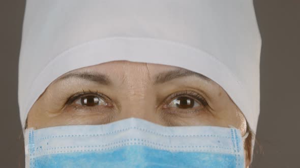 Close-up shot of a caucasian female doctor approvingly blinking and ...
