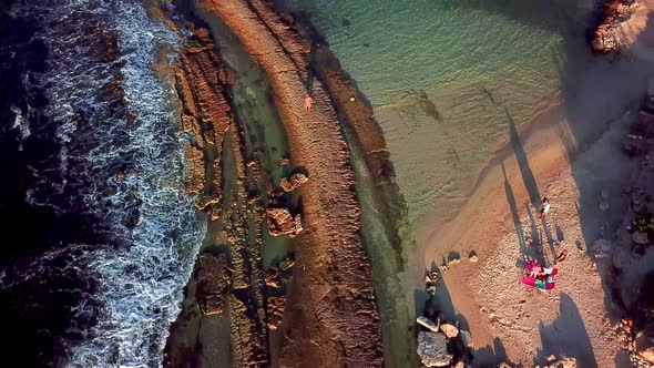 Tilt up aerial view of Kanoa Beach, family on the shore enjoying the ...