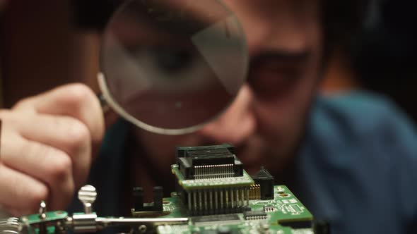 Hacker Looking at Microchip Using Magnifier Closeup, Stock Footage