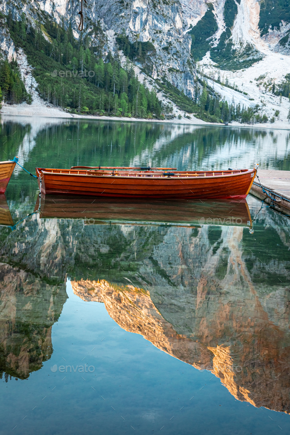 Wooden boat on mountain lake in the Lago di Braies Stock Photo by Shaiith