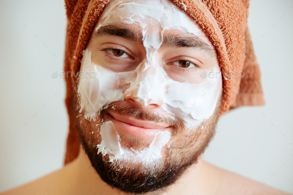 close up, funny bearded man, with a white mask on his face poses for ...