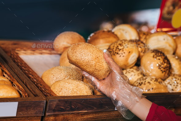 partial view of shopper choosing loaf of bread in store Stock Photo by ...