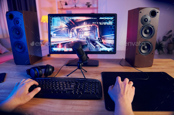 Hands on the mouse and keyboard. Online streamer playing FPS shooter ...