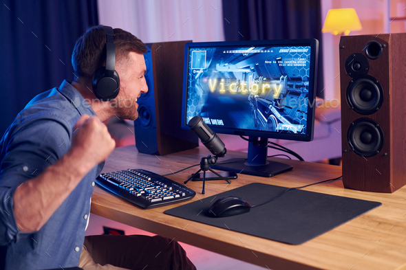 Celebrating the victory. Online streamer playing FPS shooter game at ...