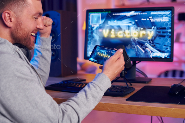 Celebrating the victory. Online streamer playing FPS shooter game at ...