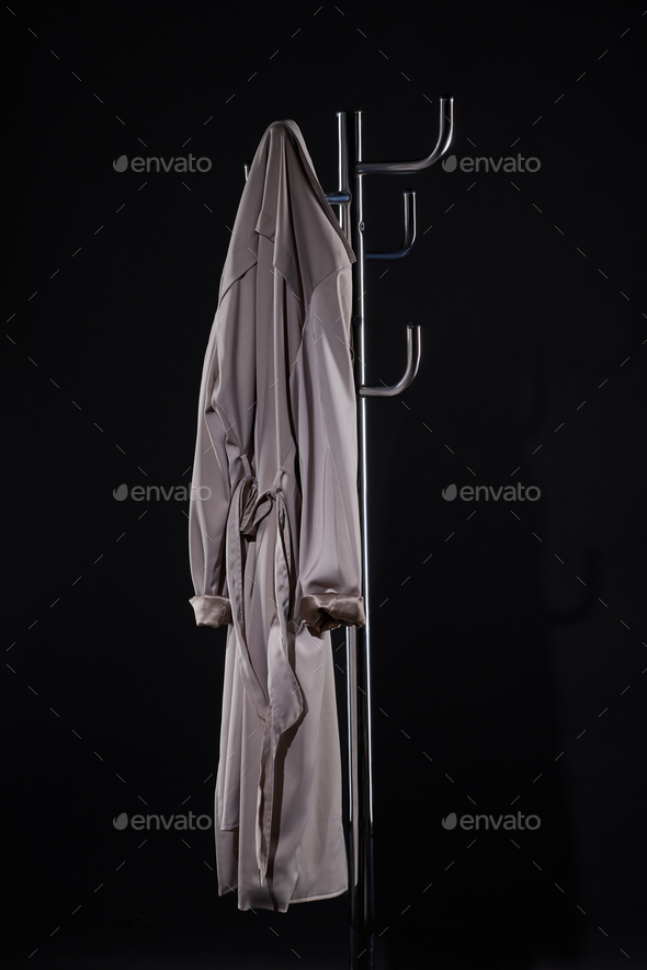 trench coat hanging on coat rack isolated on black Stock Photo by ...