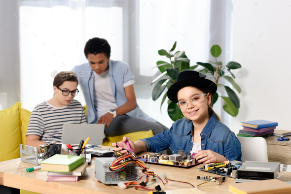multicultural teen boys using laptop and female kid fixing computer ...