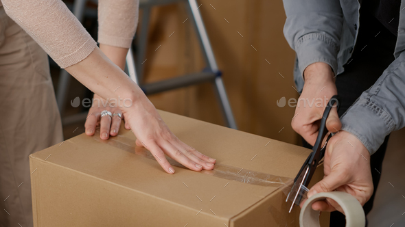 Couple using adhesive tape to pack things in cardboard boxes Stock ...