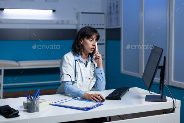 Doctor talking on landline phone for healthcare checkup Stock Photo by ...