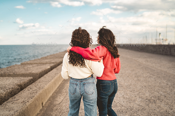 back view of young women hugging Stock Photo by baffos | PhotoDune