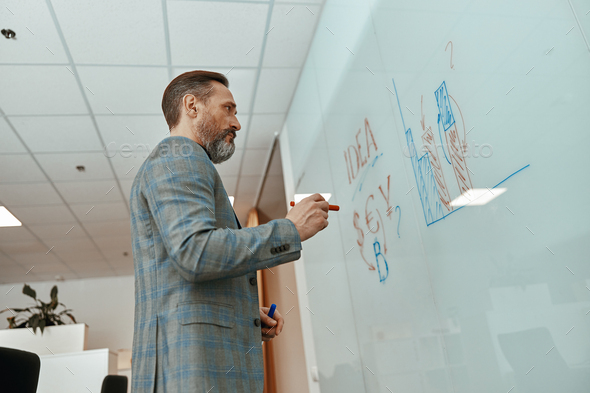 Caucasian man writing on whiteboard for his presentation Stock Photo by ...