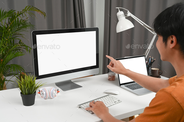 Side view of young man hand pointing on screen of computer while siting ...