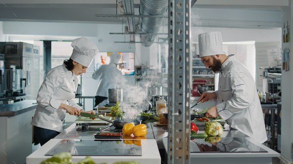Team of cooks preparing fresh ingredients to follow culinary recipe ...