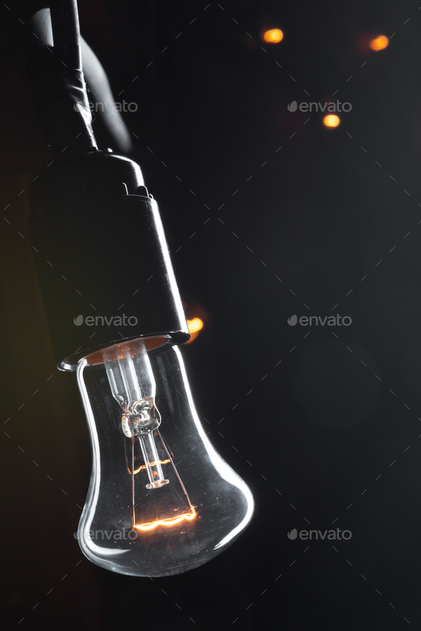 A classic Edison light bulb on dark background with space for text ...