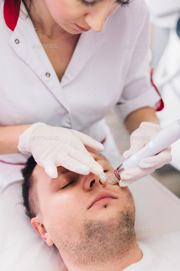 Cosmetologist doing hydrafacial treatment on man face Stock Photo by ...