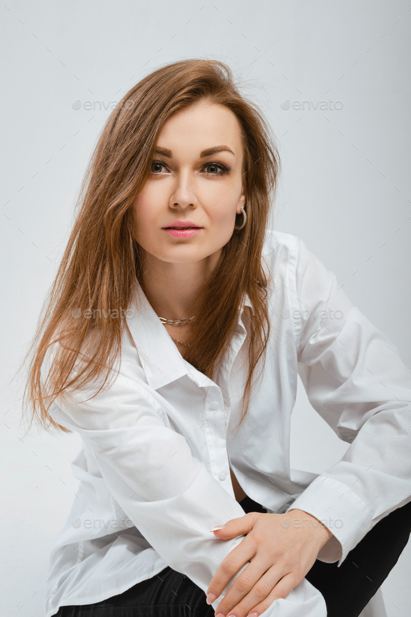 Studio portrait of beautiful young woman with no makeup looking at ...
