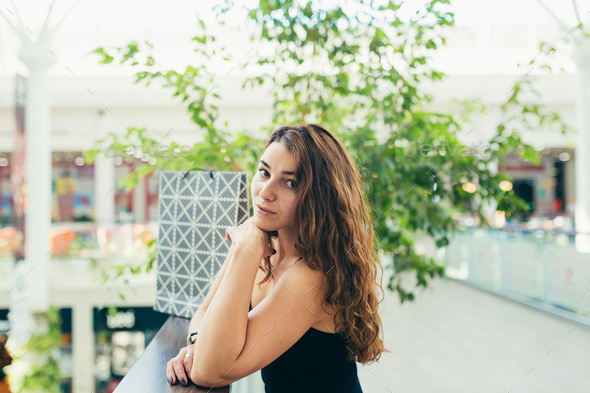 Portrait of a beautiful young woman in the mall who is shopping in ...