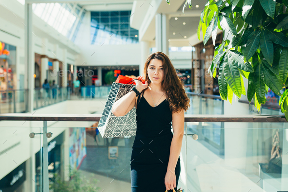 Happy beautiful young woman girl in a black dress is shopping in the ...