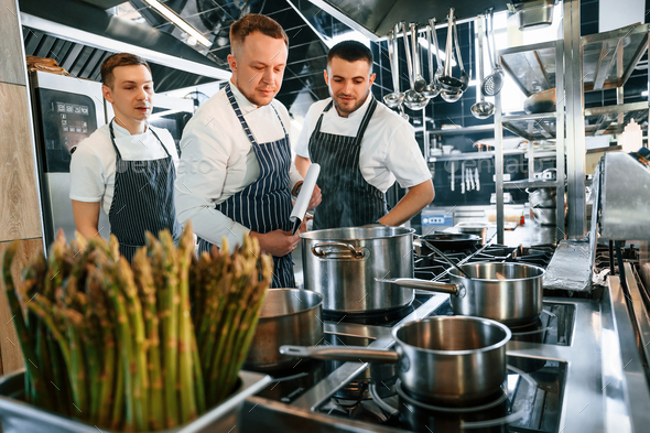 Reading the documents. Kitchen workers is together preparing the food ...