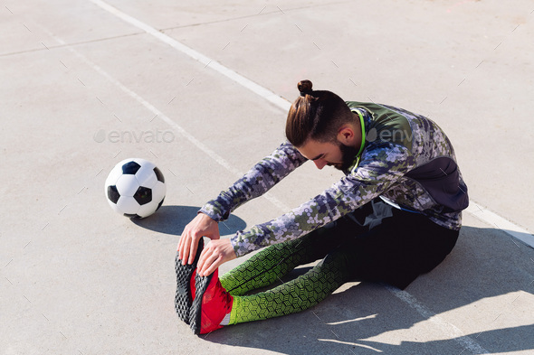 soccer player stretching legs sitting on the floor Stock Photo by Raul ...