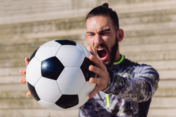 football ball in the hands of sportsman screaming Stock Photo by Raul ...