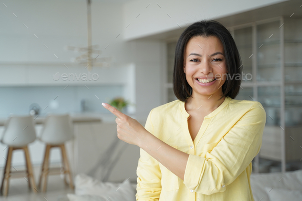 Smiling female homeowner pointing aside, recommending service, real ...