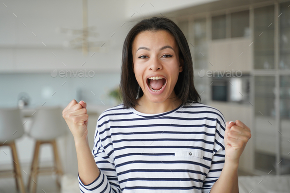 Excited happy woman makes yes gesture, celebrates relocation at new ...