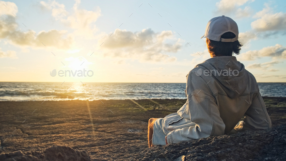 Man on a beach is looking distance during beautiful summer sunset ...