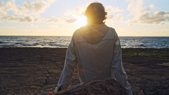 Man on a beach is looking distance during beautiful summer sunset ...