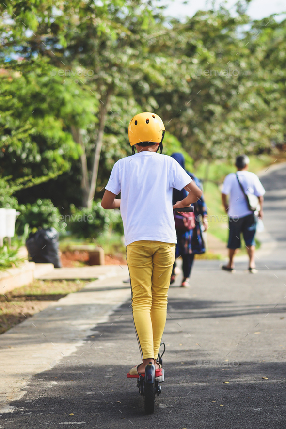 Back view electric scooter riders on the road Stock Photo by Garakta-Studio