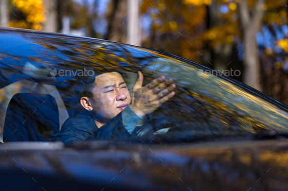 Furious angry asian man standing in a traffic jam beeps and hurries ...