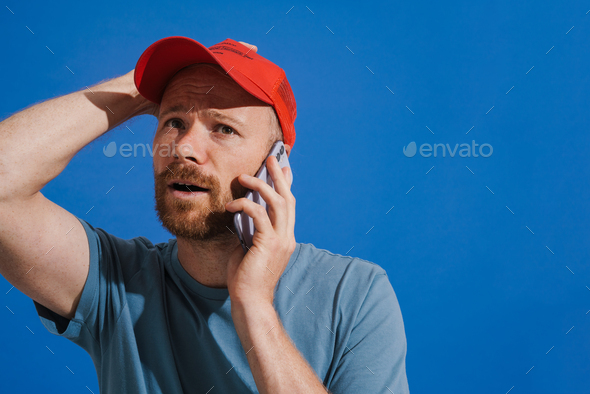 White ginger man wearing cap talking on mobile phone Stock Photo by ...