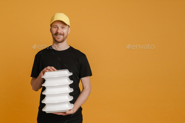 White delivery man in cap smiling while posing with lunch boxes Stock ...