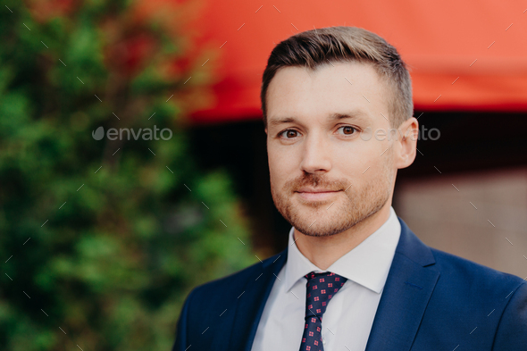 Headshot of attracttive successful male manager has confident serious ...