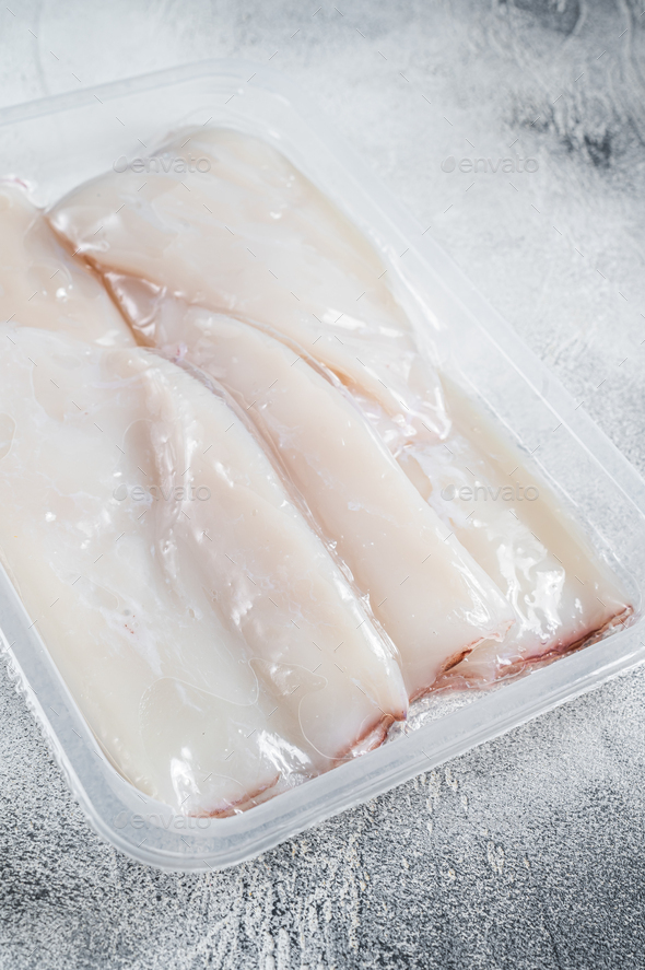Fresh Raw Squid or Calamari in a vacuum package on a kitchen table ...
