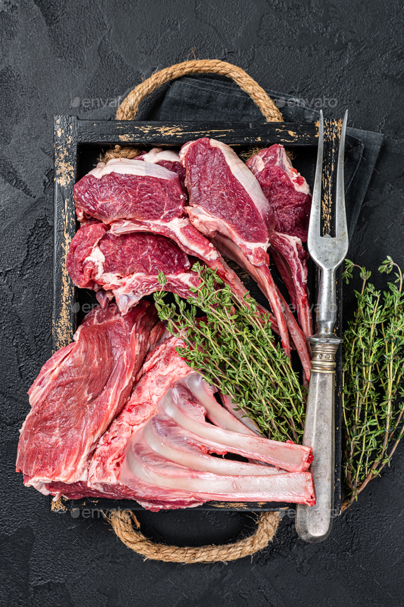 Uncooked Raw Rack and lamb, mutton rib chops in a wooden tray. Black ...