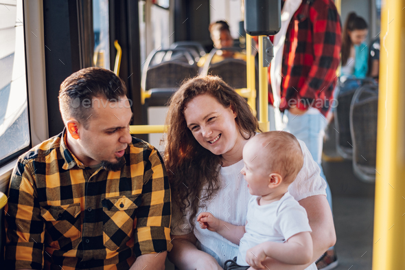 Parents riding a bus with their child during a day. Stock Photo by ...