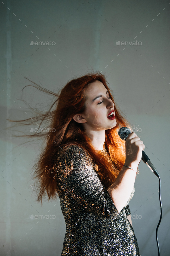 Portrait of redhead female singer woman in sparkly evening dress ...