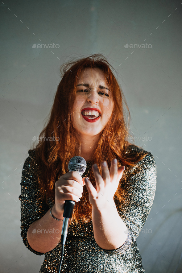 Portrait of redhead female singer woman in sparkly evening dress ...