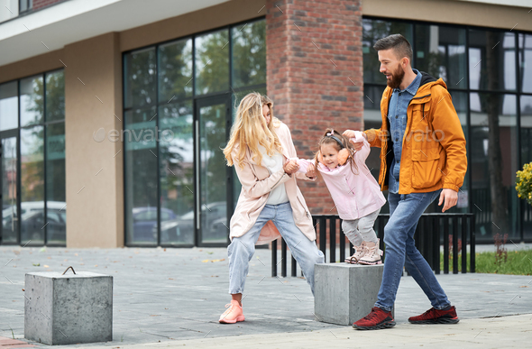 Happy family with child walking down the street. Stock Photo by ...