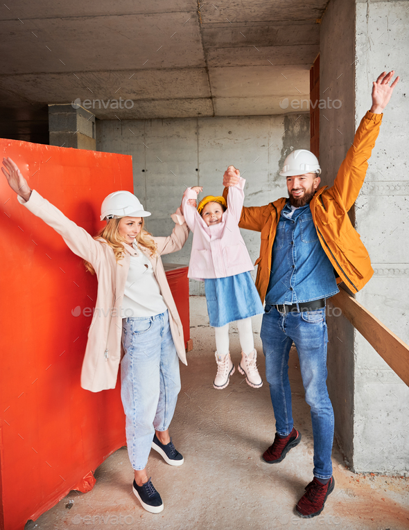 Happy family with child rejoicing at construction site. Stock Photo by ...
