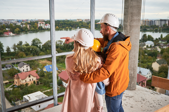 Family with child standing in building under construction. Stock Photo ...