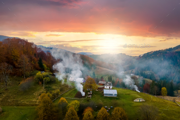 Aerial view of small shepherd houses on wide meadow between autumn ...