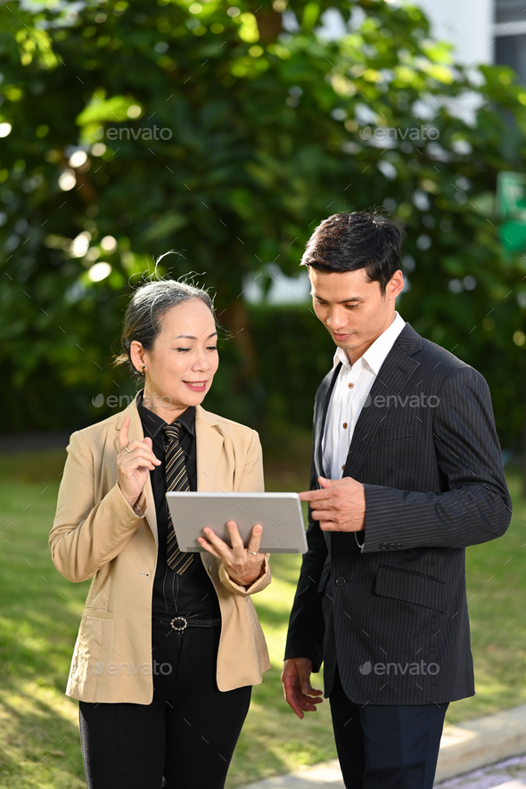 Successful investors are standing in front of office building and ...