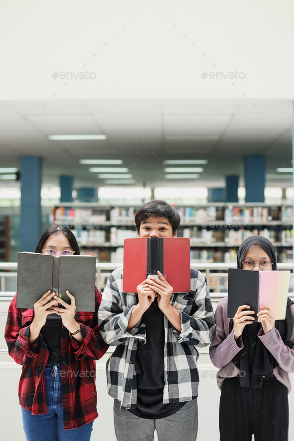Expression of students covering face by the books at library Stock ...