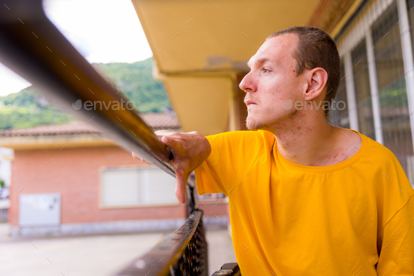 Portrait of a serious disabled person dressed in yellow in a wheelchair ...